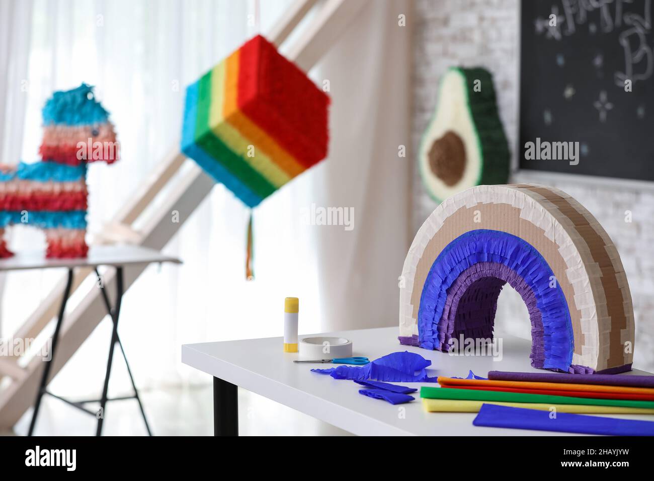 Materials for making Mexican pinata in shape of rainbow on table in ...