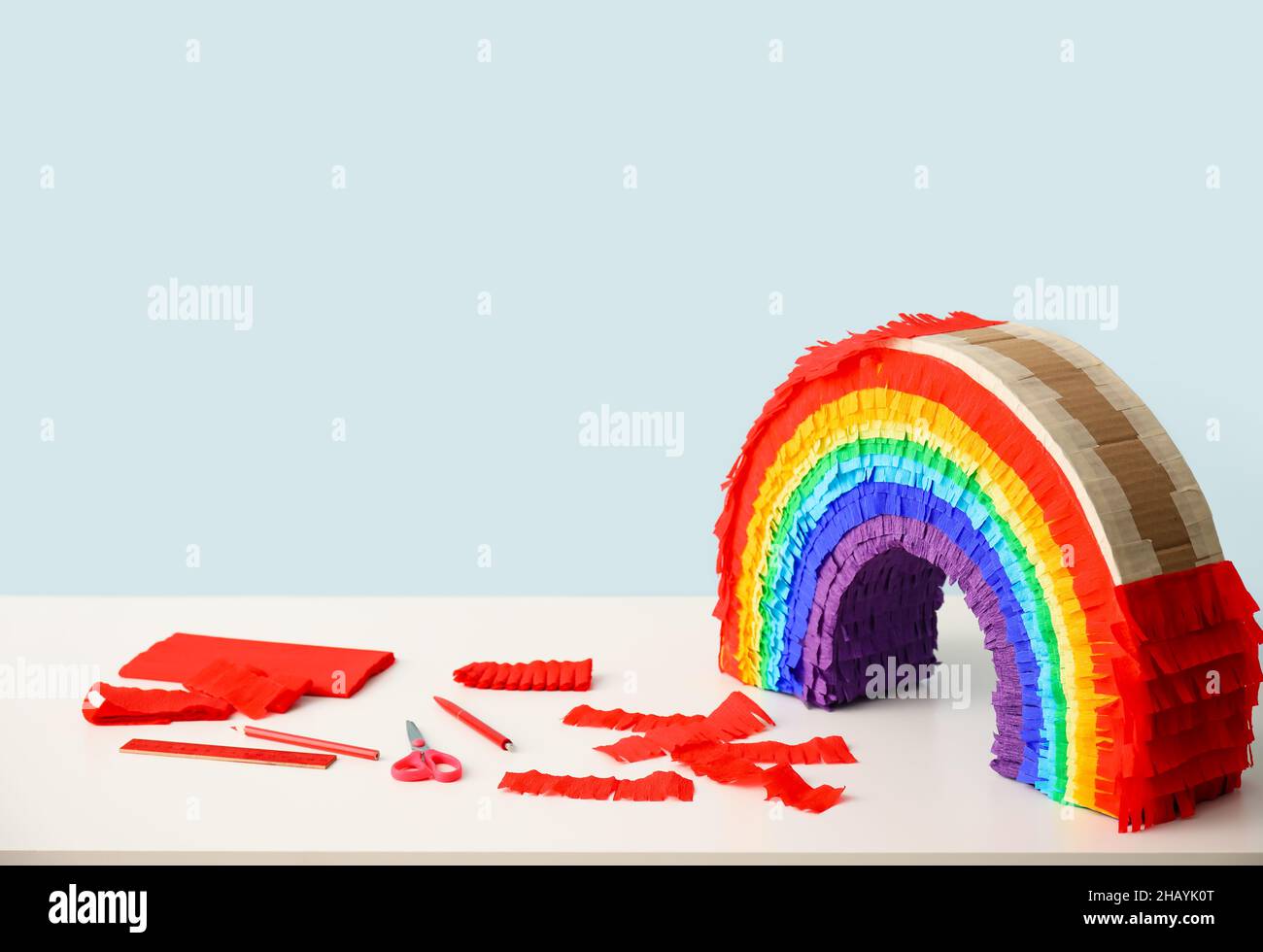 Materials for making Mexican pinata in shape of rainbow on table ...