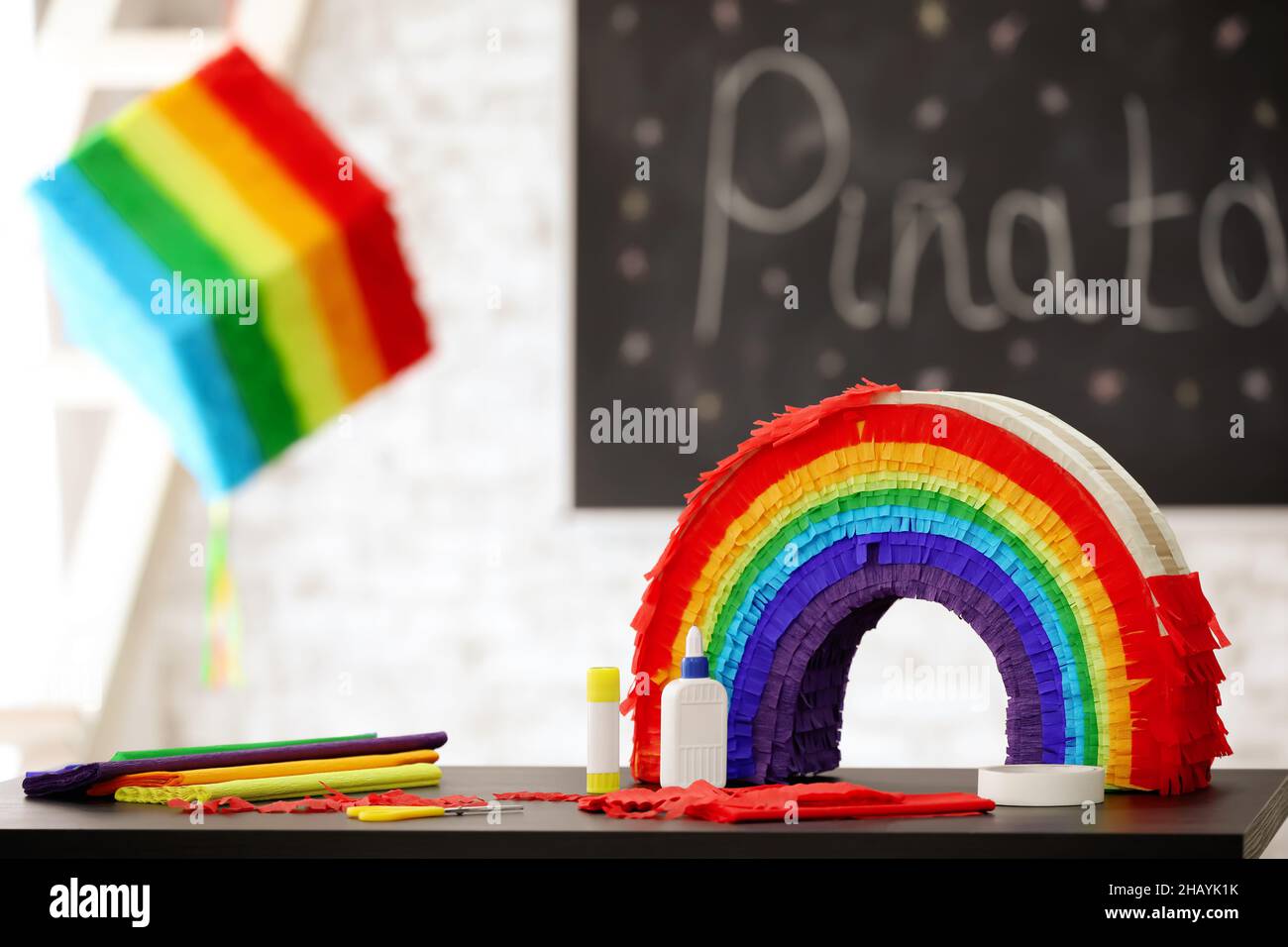 Materials for making Mexican pinata in shape of rainbow on table in ...