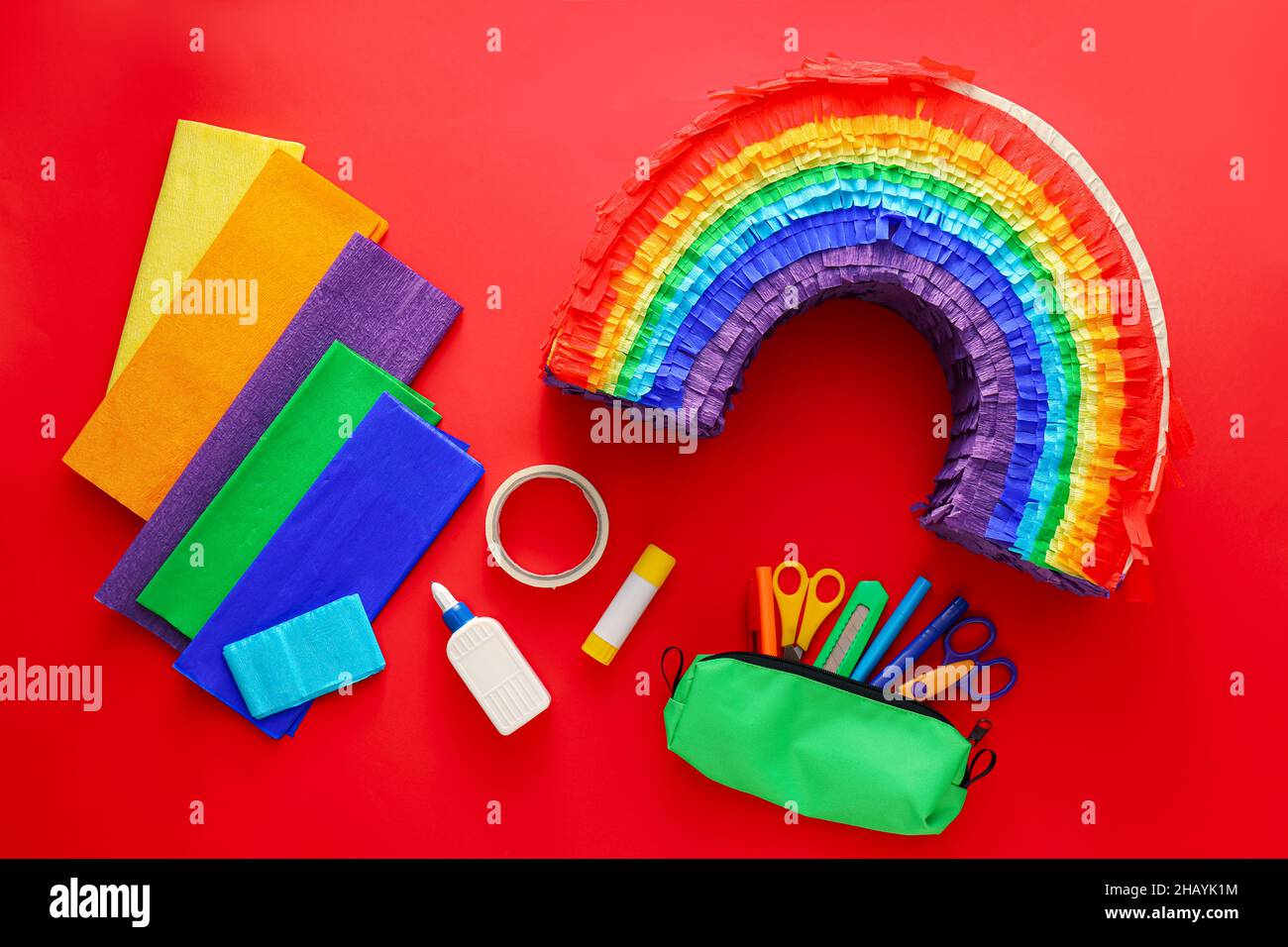Materials for making Mexican pinata in shape of rainbow on red ...