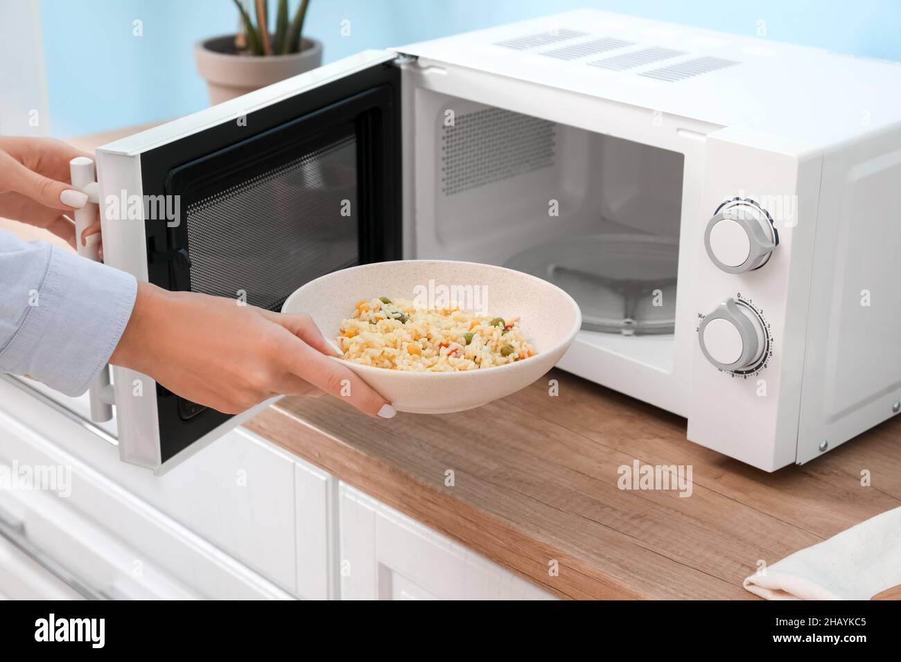Woman heating food in hi-res stock photography and images - Alamy