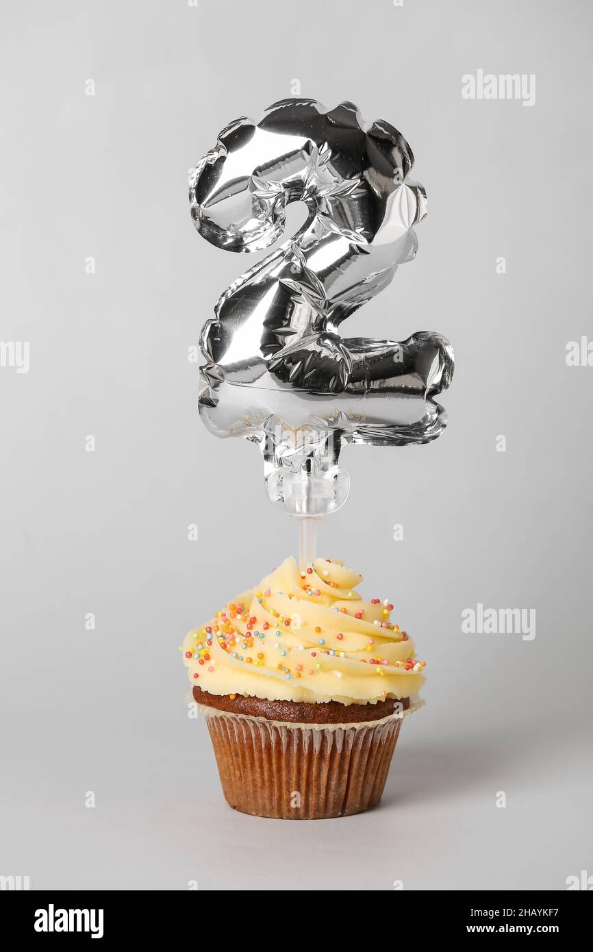 Tasty Birthday cupcake with figure 2 on grey background Stock Photo - Alamy