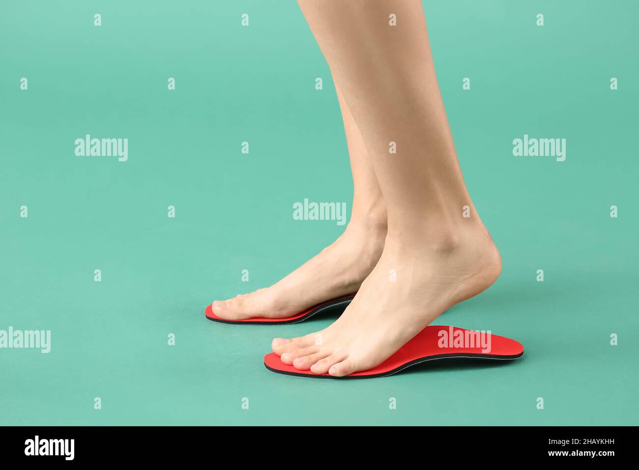 Female feet and red orthopedic insoles on green background Stock Photo ...