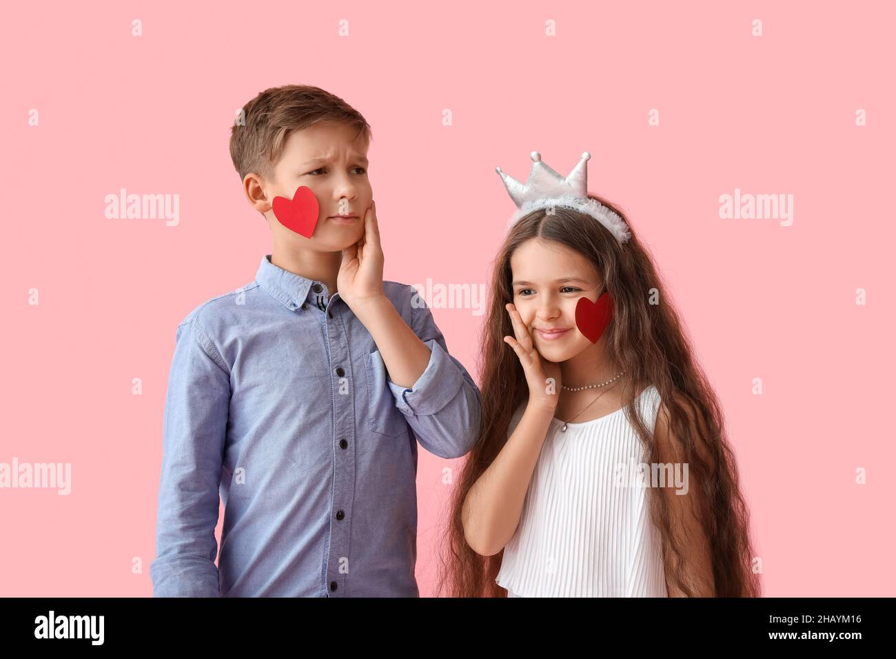 Little children with hearts on cheeks against color background ...