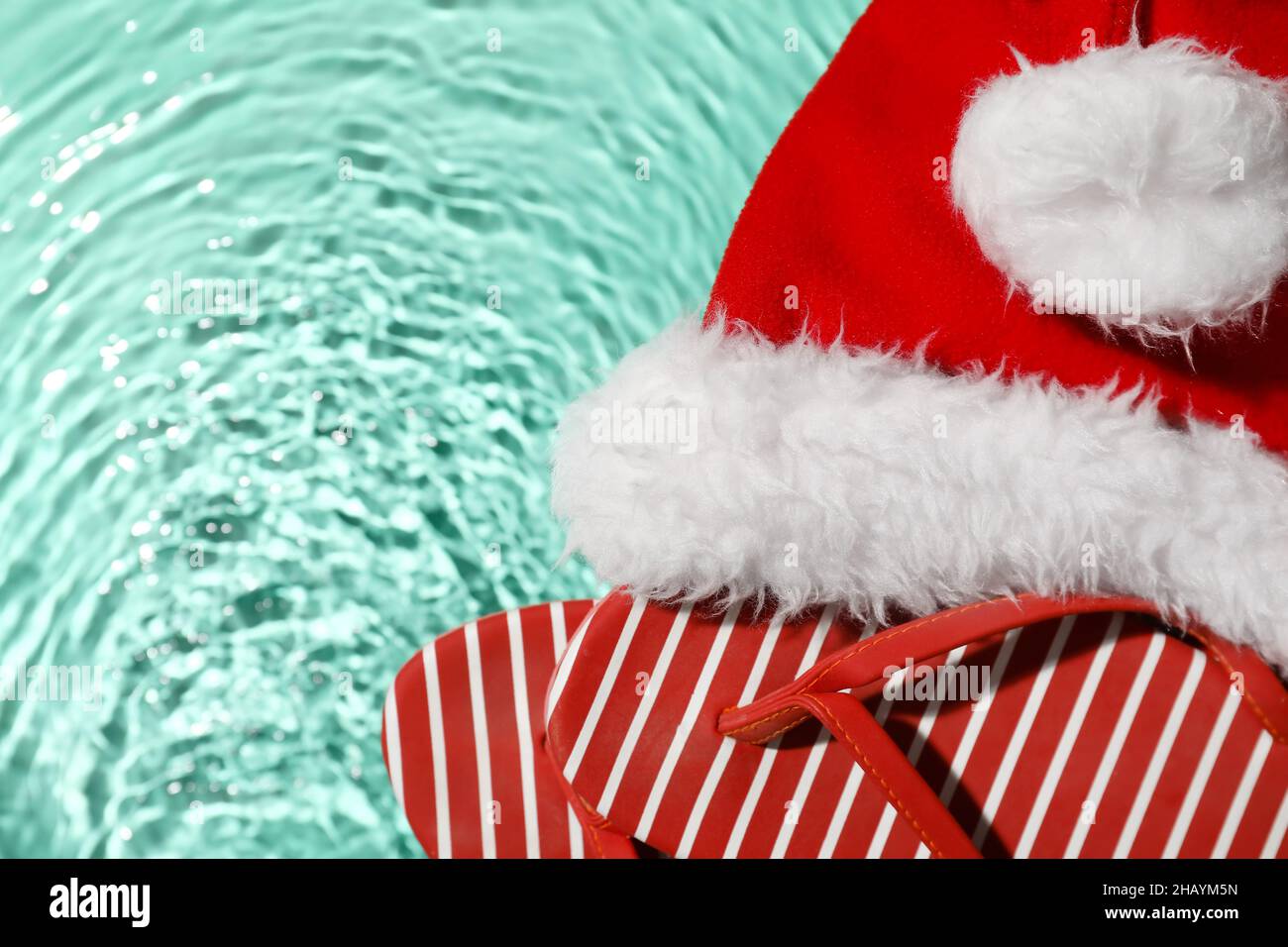 Santa hat and flip-flops near swimming pool Stock Photo - Alamy