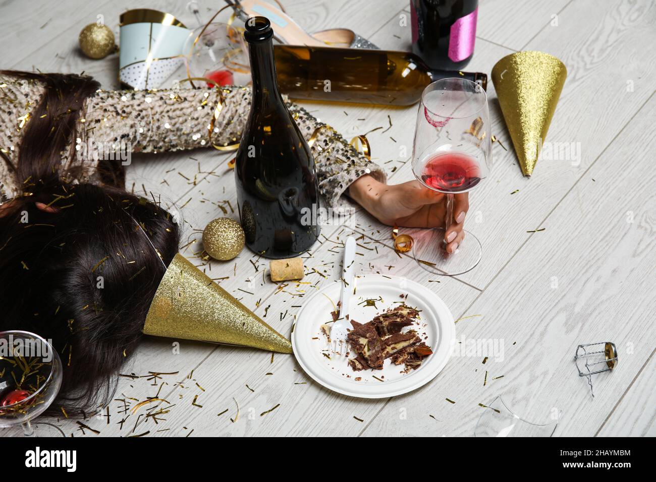 Drunk young woman with wine glass lying on floor after party Stock ...