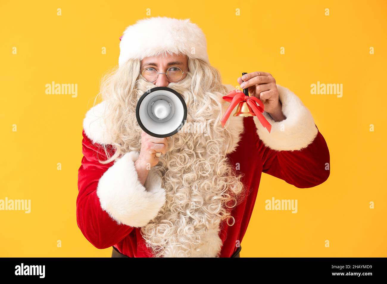 Santa Claus with megaphone and Christmas bell on yellow background ...