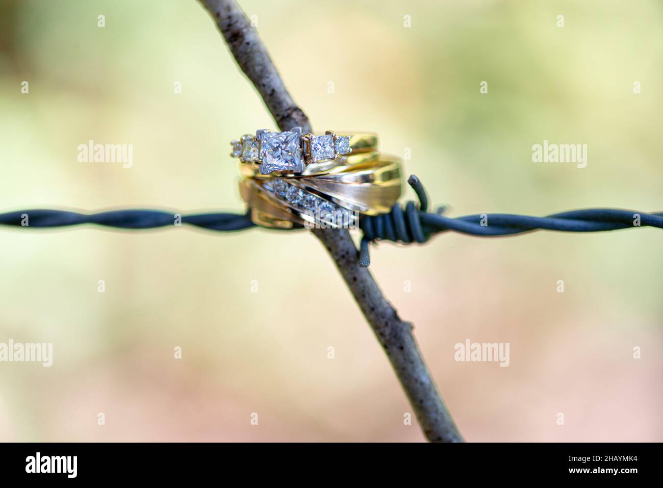 Gold wedding rings with square diamonds on wire fence Stock Photo - Alamy