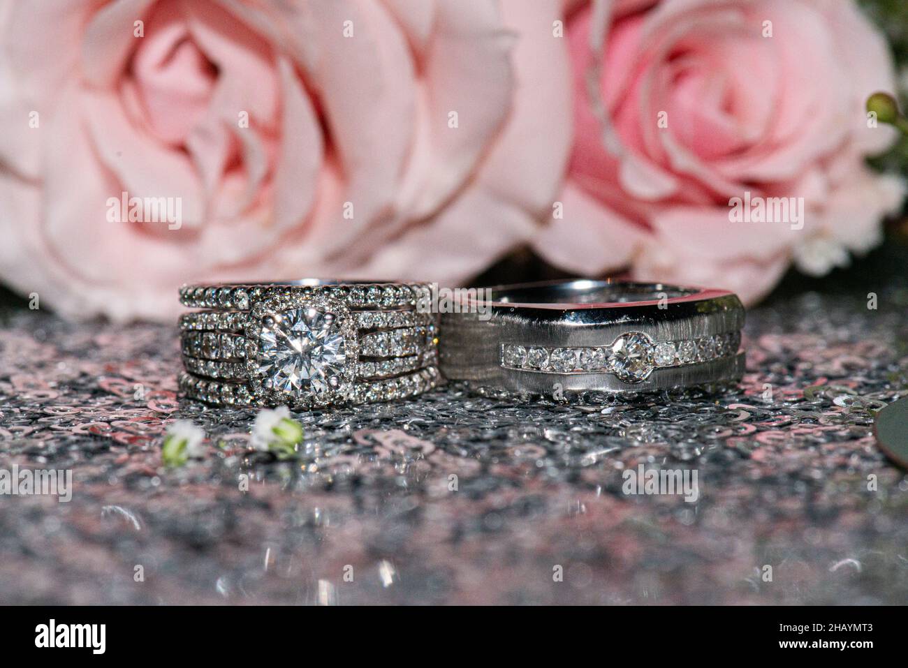Blingy white gold wedding rings with diamonds on glass reflective ...