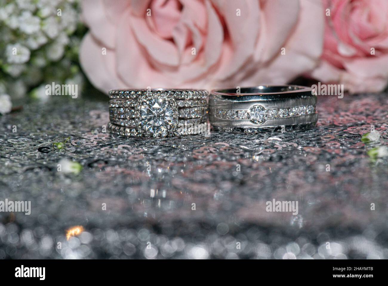 Blingy white gold wedding rings with diamonds on glass reflective ...