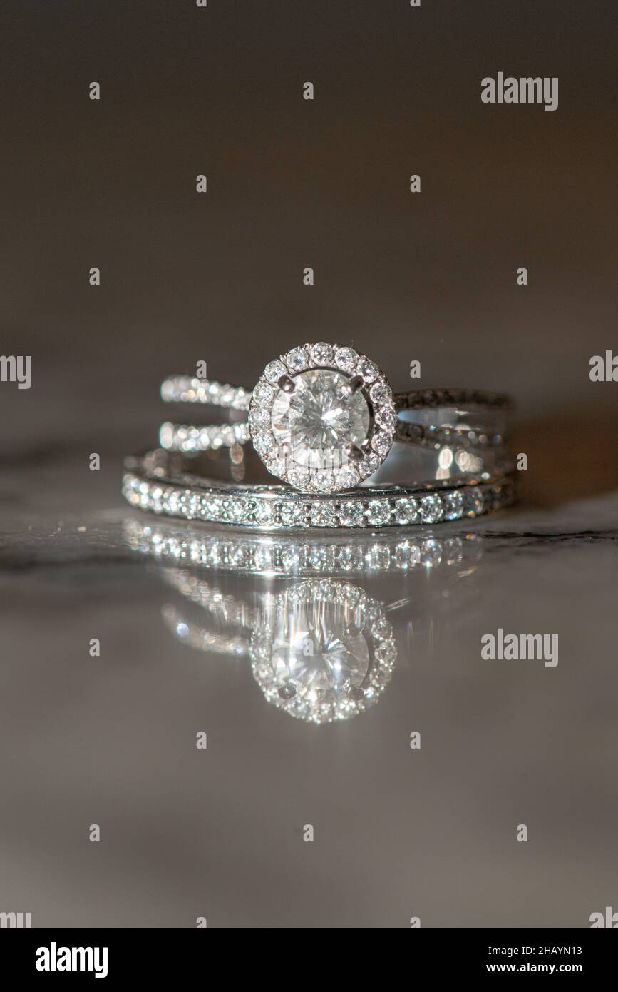 White gold bride and grooms wedding rings with diamonds on reflective ...