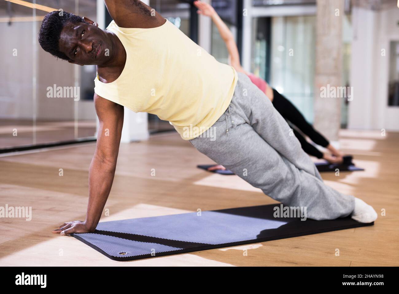 Man practicing pilates exercises at group class Stock Photo - Alamy