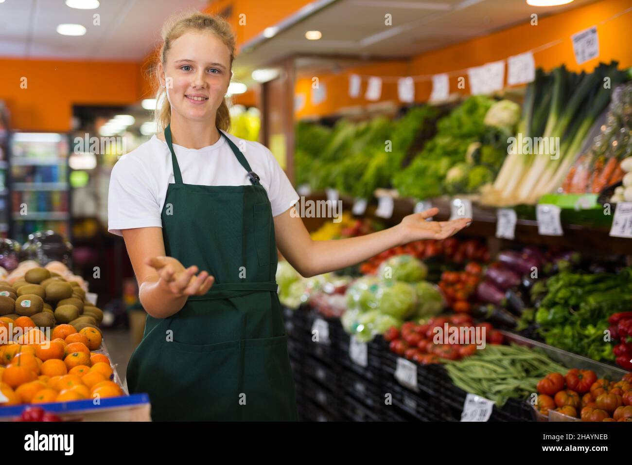 Pretty young saleswoman posing at grocery Stock Photo - Alamy