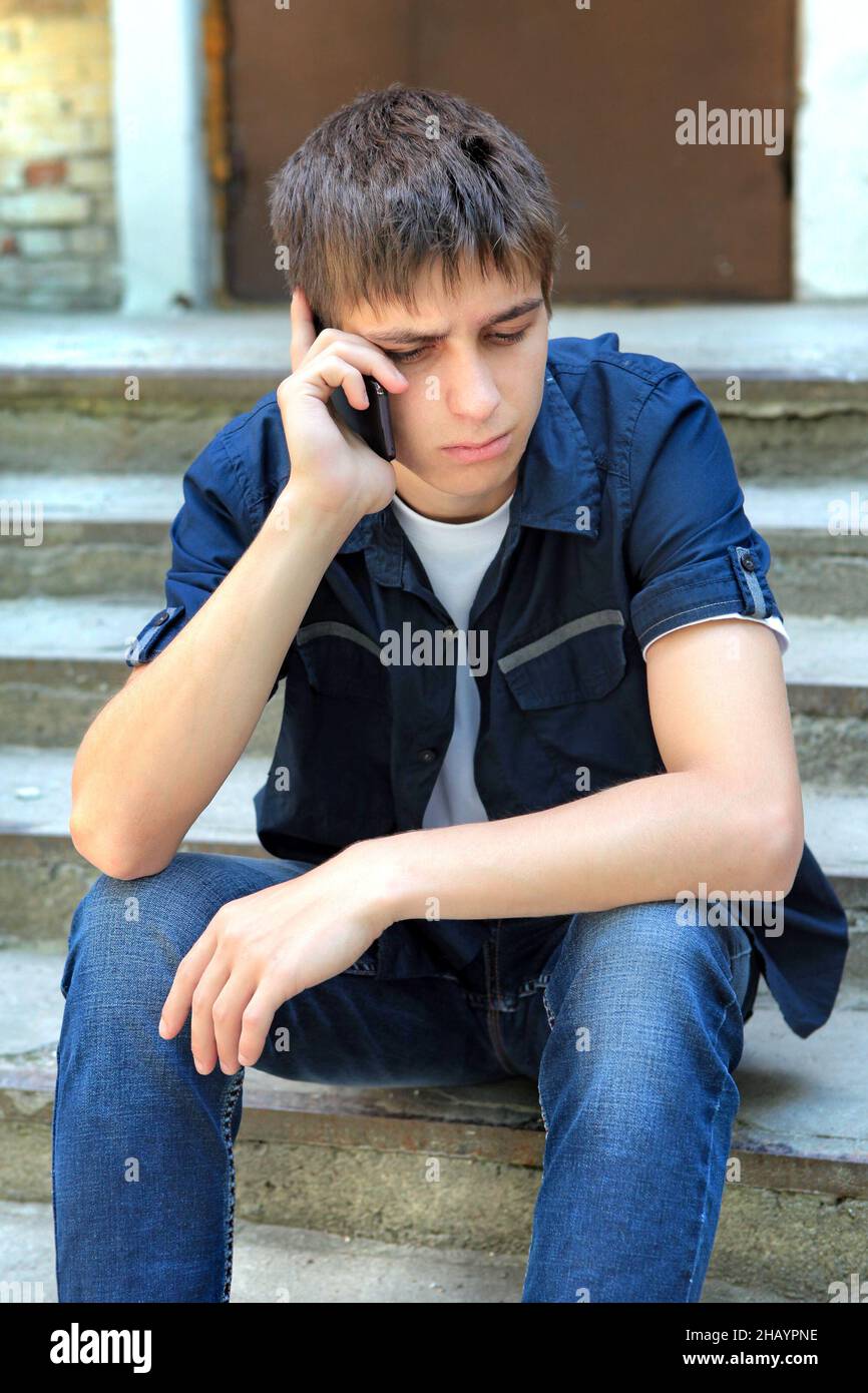 Sad Teenager with Cellphone on the landing steps of the Old House Stock ...