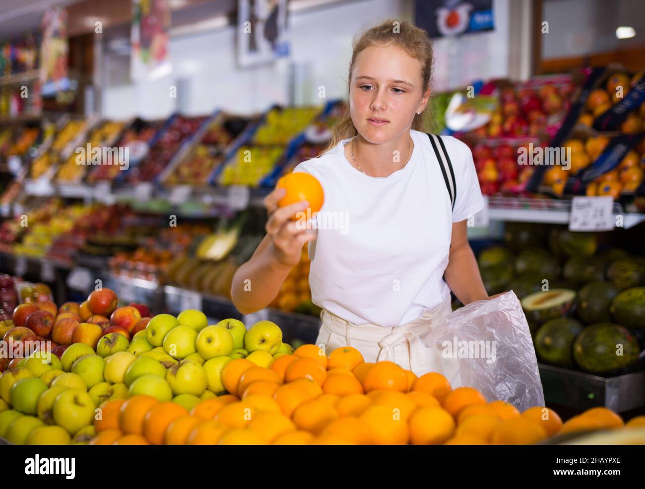 Girl consumer choosing oranges at supermarket Stock Photo - Alamy