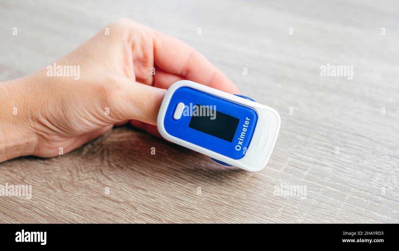 Checking oxygen level at home with home oximeter, patient measuring the ...