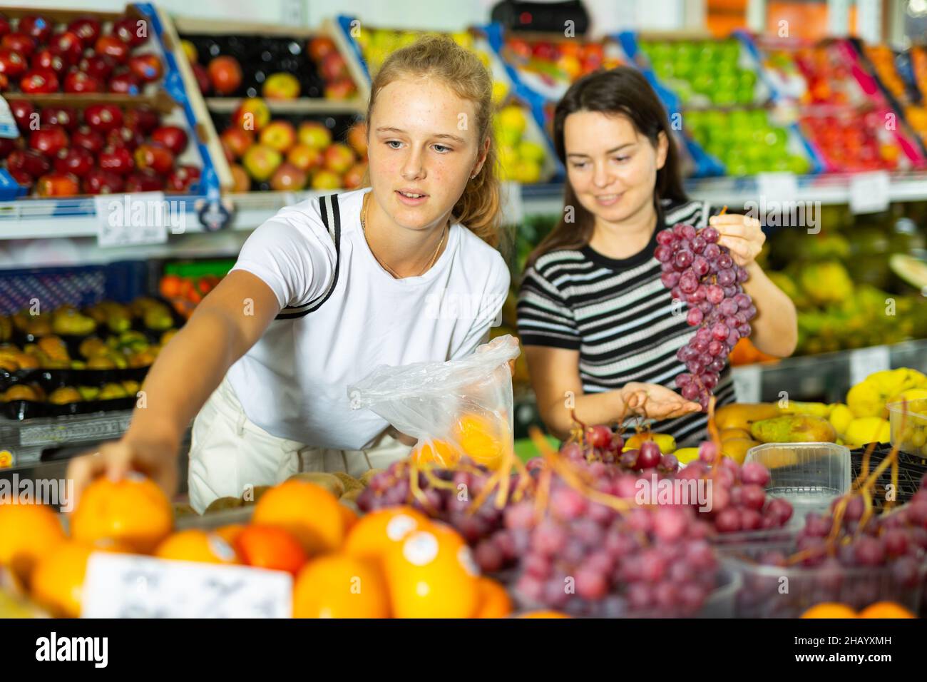 Teenage girl and her mother buying grape at grocery Stock Photo - Alamy