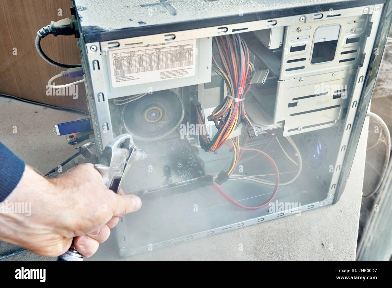 Employee cleans an open old computer with air duster cleaning spray gun ...