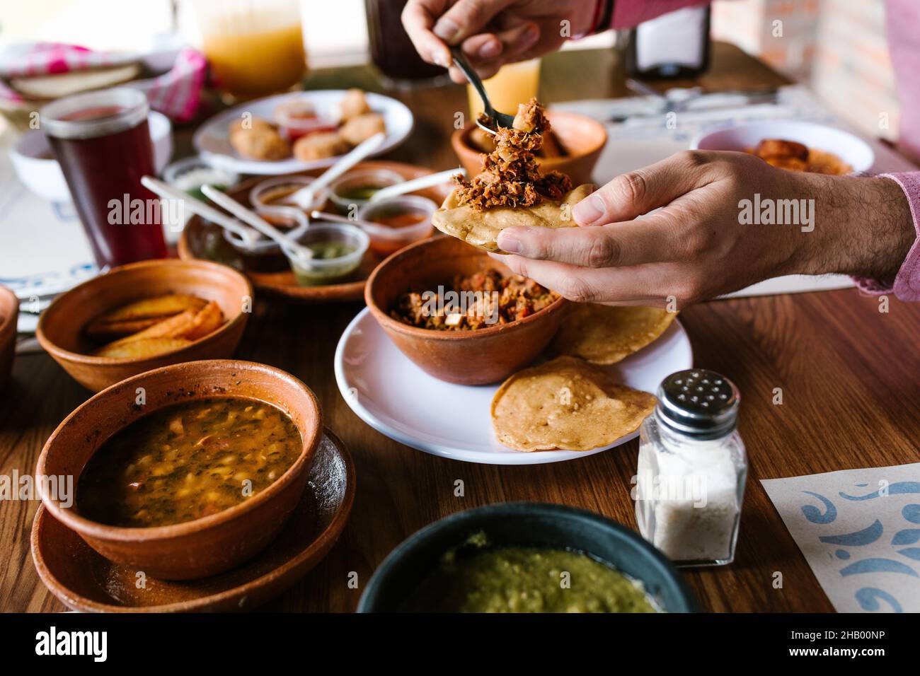Hand of man eating mexican tostadas or tacos tortillas and traditional ...