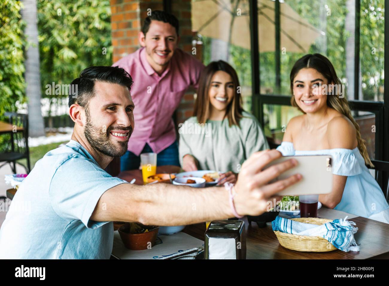 Group of latin friends taking a photo selfie and eating mexican food in ...