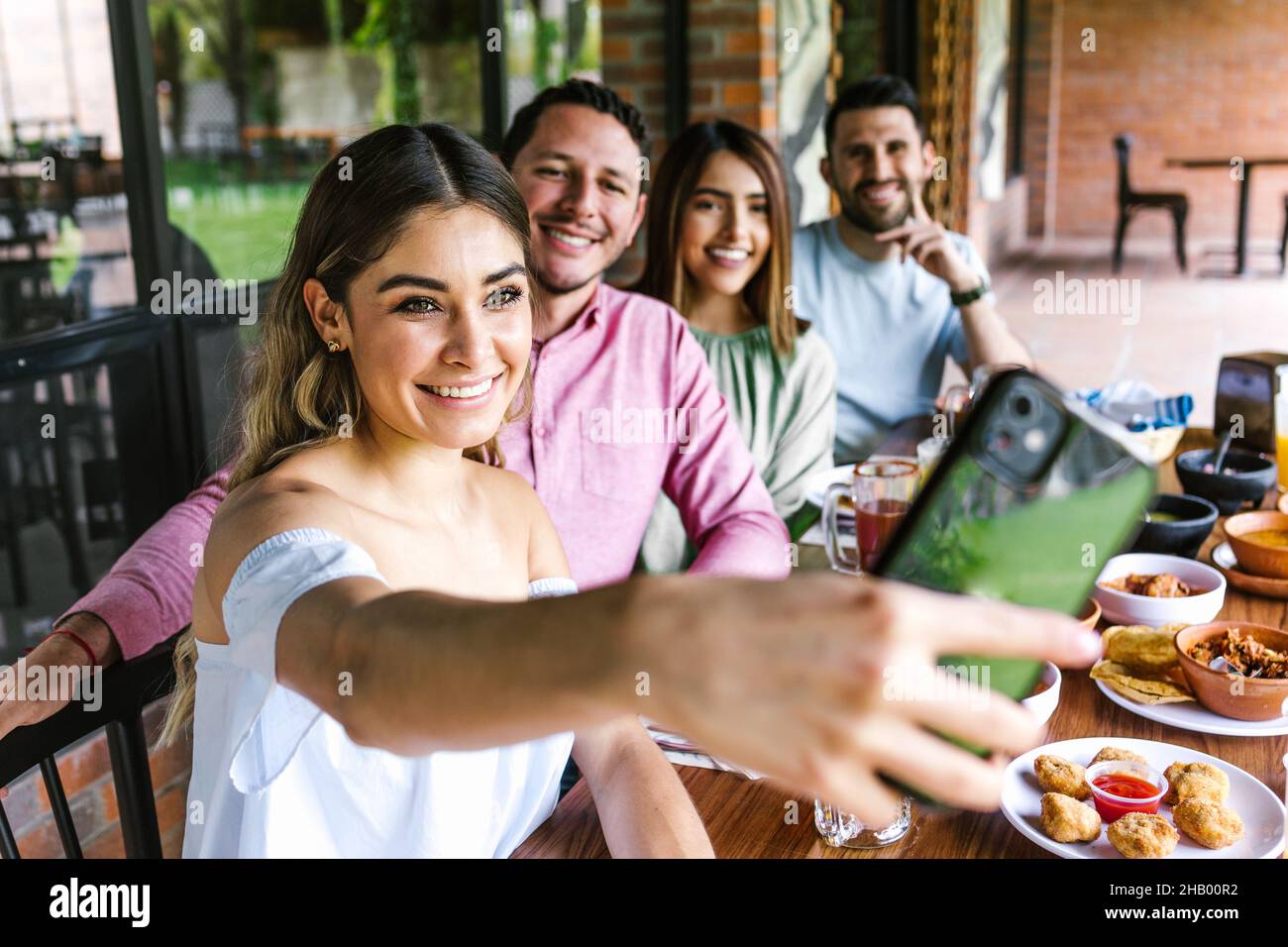 Group of latin friends taking a photo selfie and eating mexican food in ...