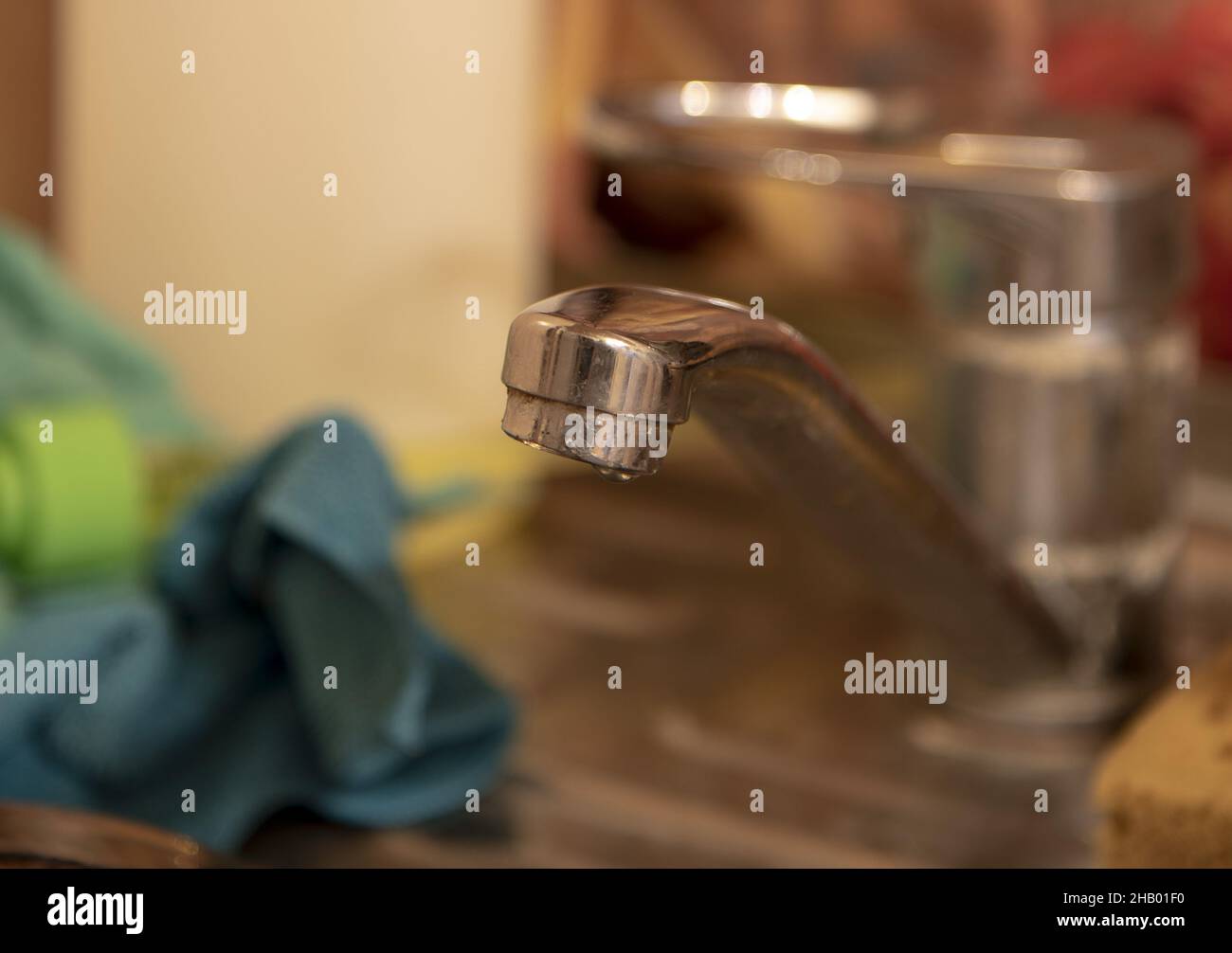 The water tap over the kitchen sink with dirty dishes. Focus on the ...