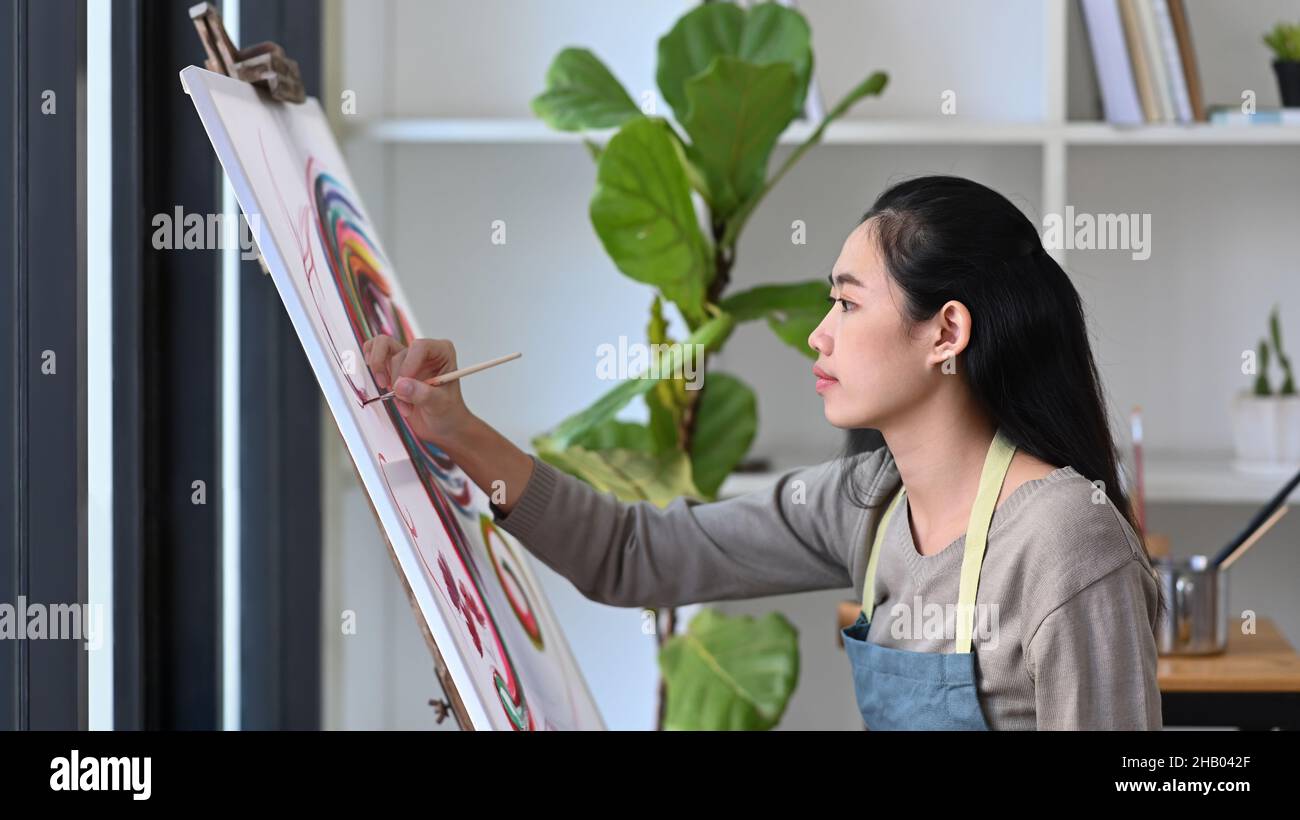 Pretty asian woman painter painting a picture in art studio Stock Photo - Alamy