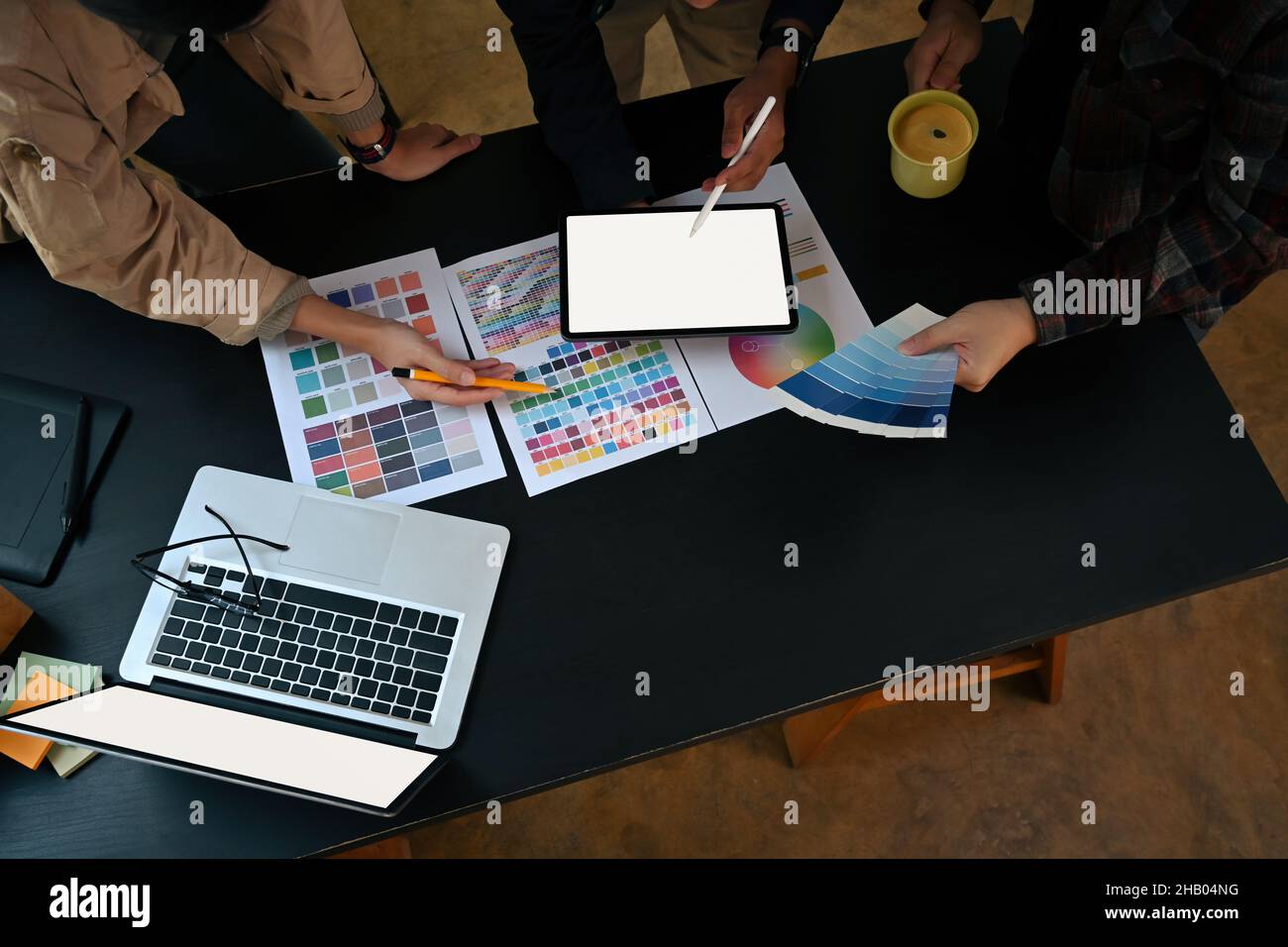 Overhead view team of graphic designer working with color chart and ...