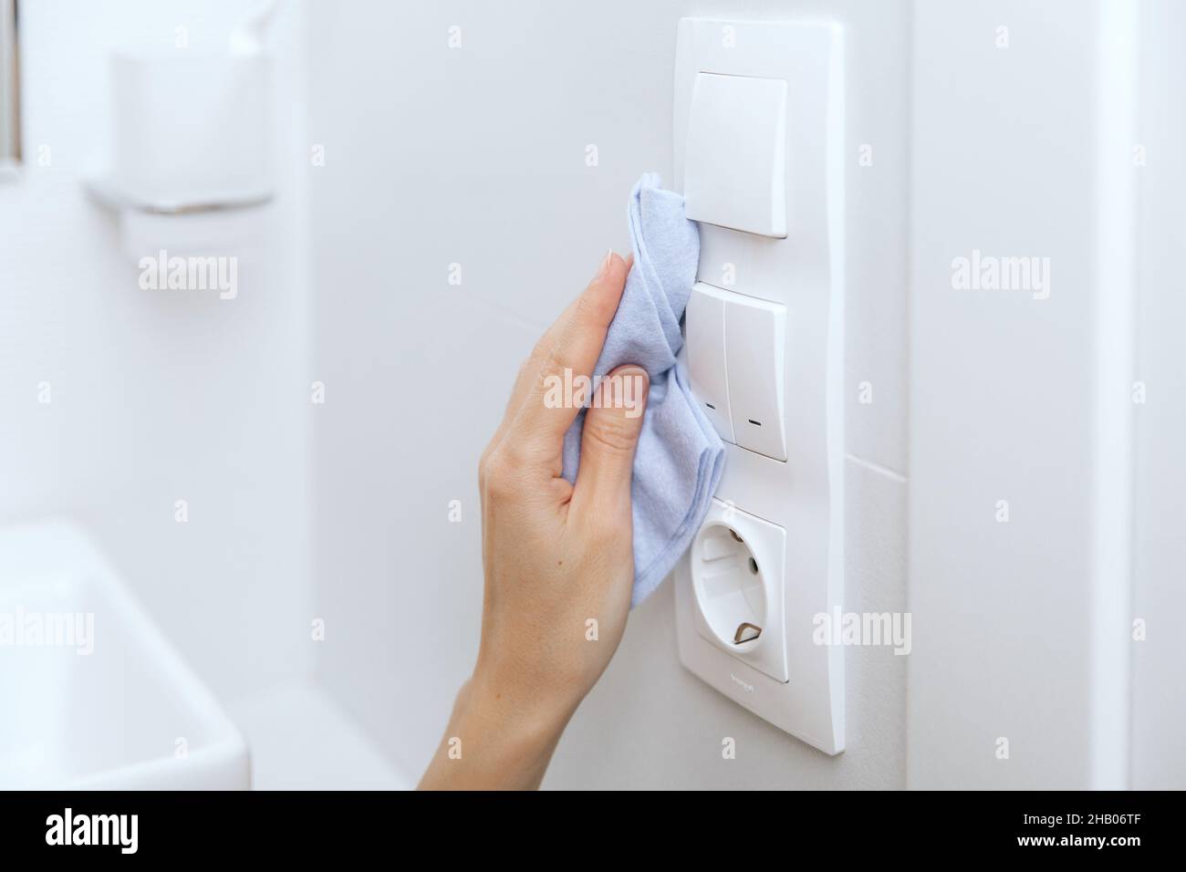 Cleaning switches and sockets with a microfiber cloth. Woman hand using ...