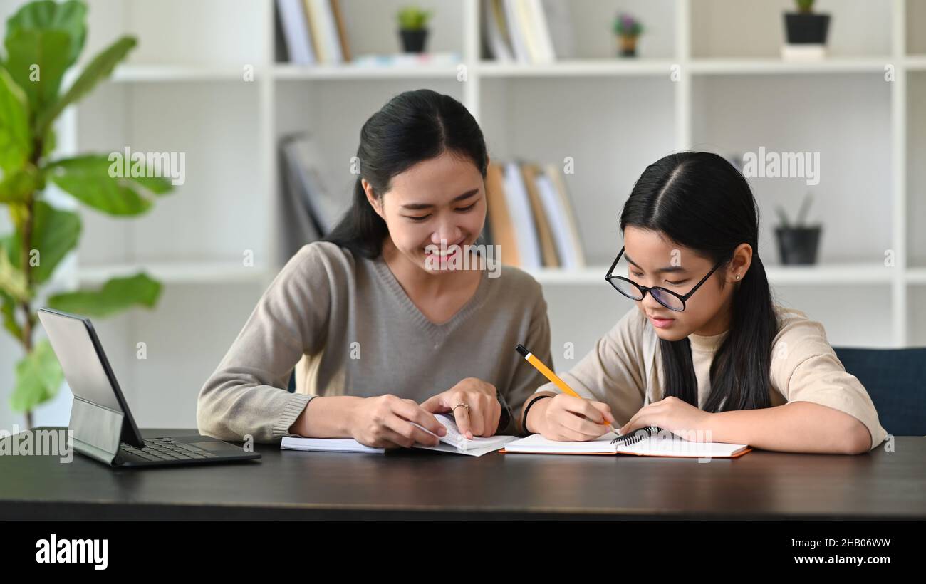 Happy asian mother helping her daughter doing homework Stock Photo - Alamy