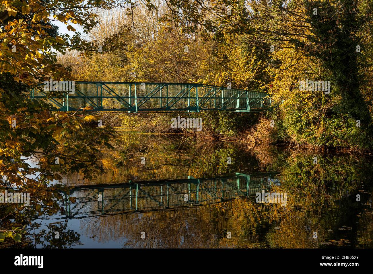 A pedestrian bridge over the Royal Military Canal. with autumnal trees ...