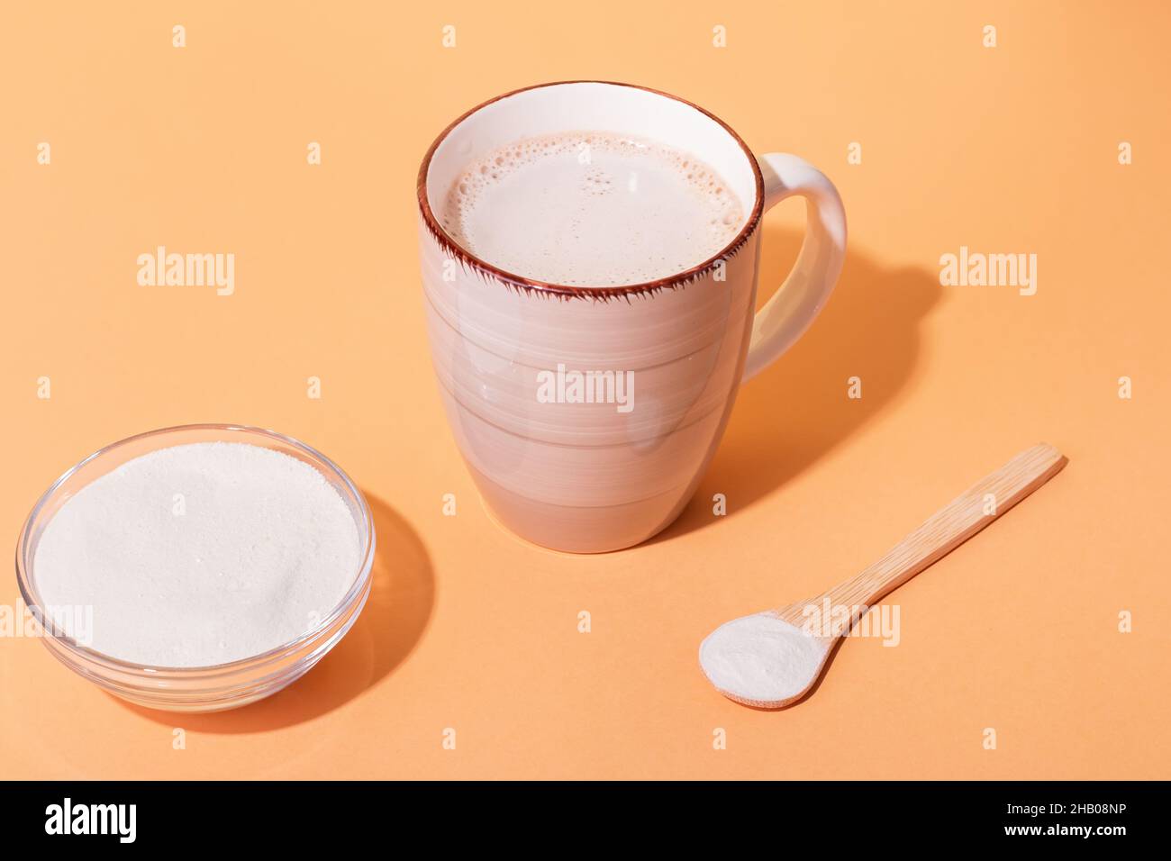 Coffee mug and collagen powder on table. Bright, minimal composition ...