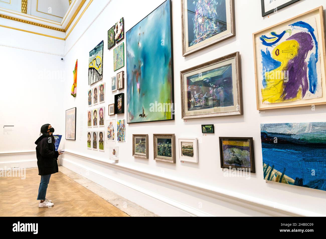 Visitor looking at artworks at the RA Summer Exhibition 2021, London ...