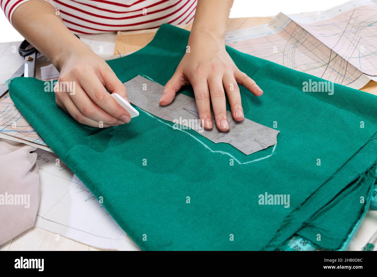 Close-up hands of female seamstress, dressmaker making dress or suit ...