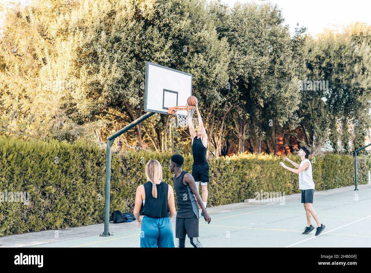Tall man scoring during a basketball match in an open court Stock Photo ...