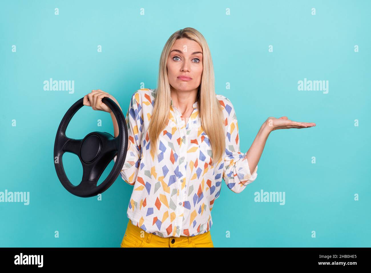 Photo of unsure young blond lady drive shrug shoulders wear printed ...