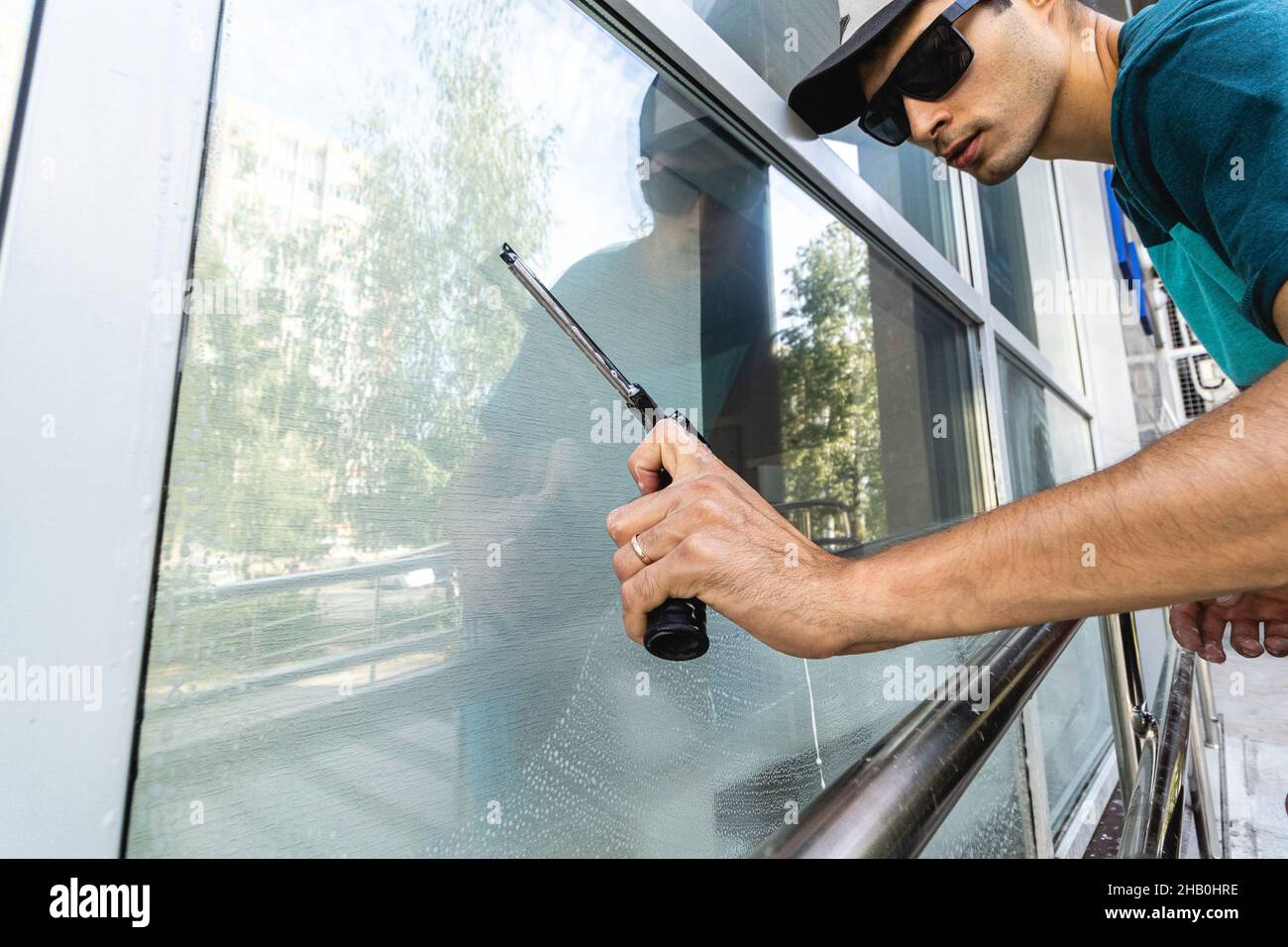 Male professional cleaning service worker in overalls cleans the ...