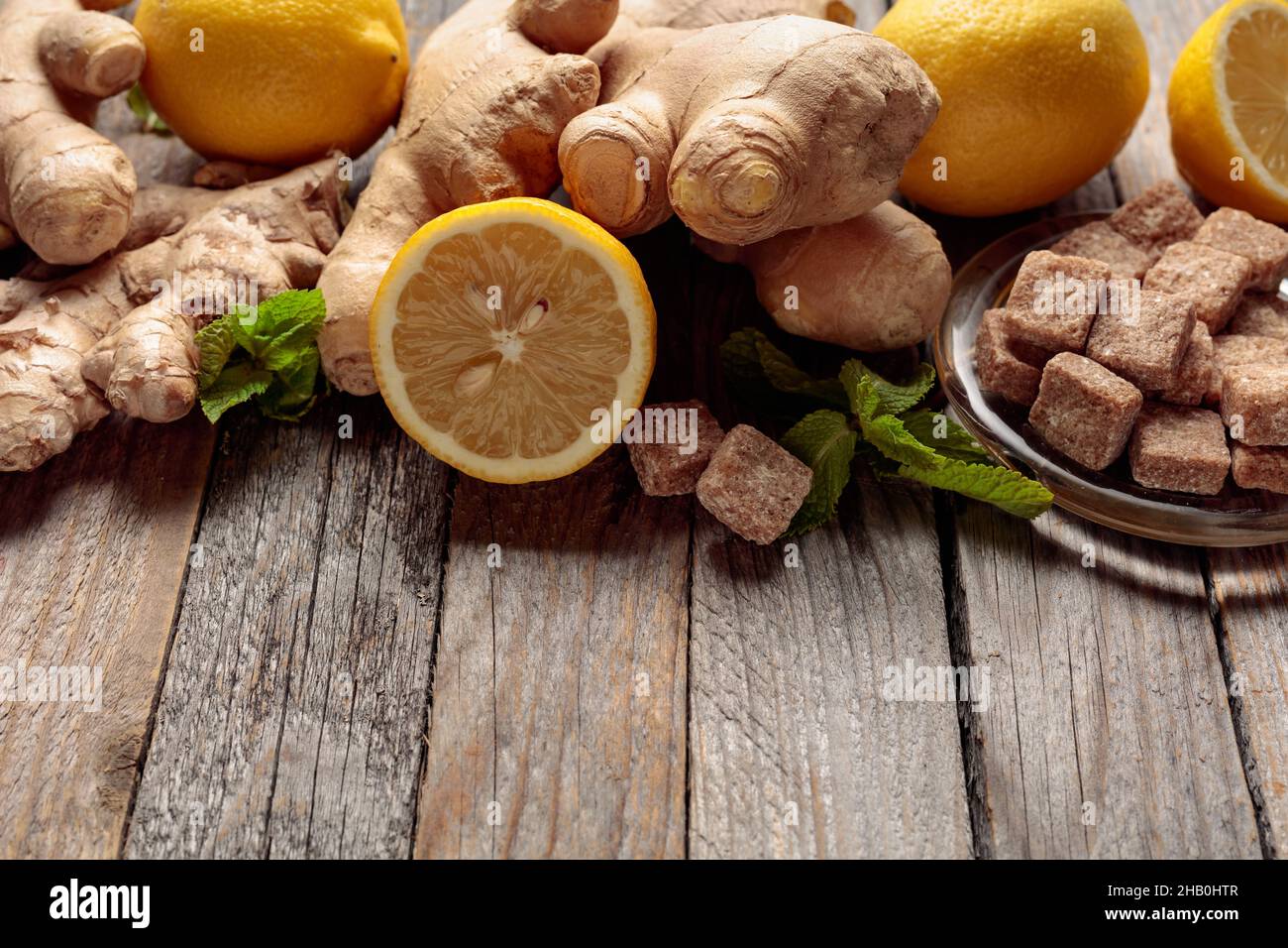 Ingredients for ginger tea. Ginger, lemon, mint and brown sugar on a ...
