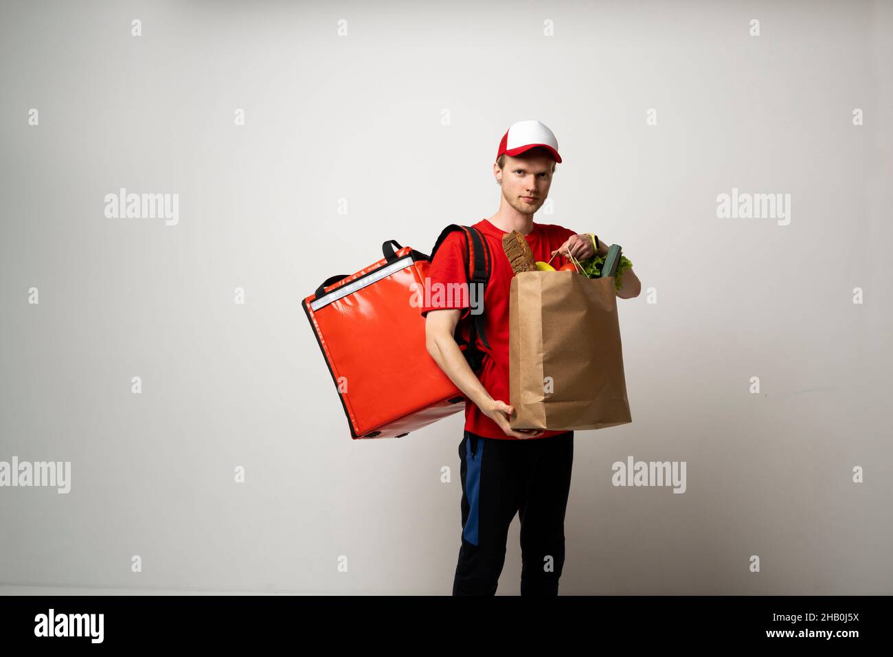 Delivery Concept. Handsome delivery man carrying package box of grocery ...
