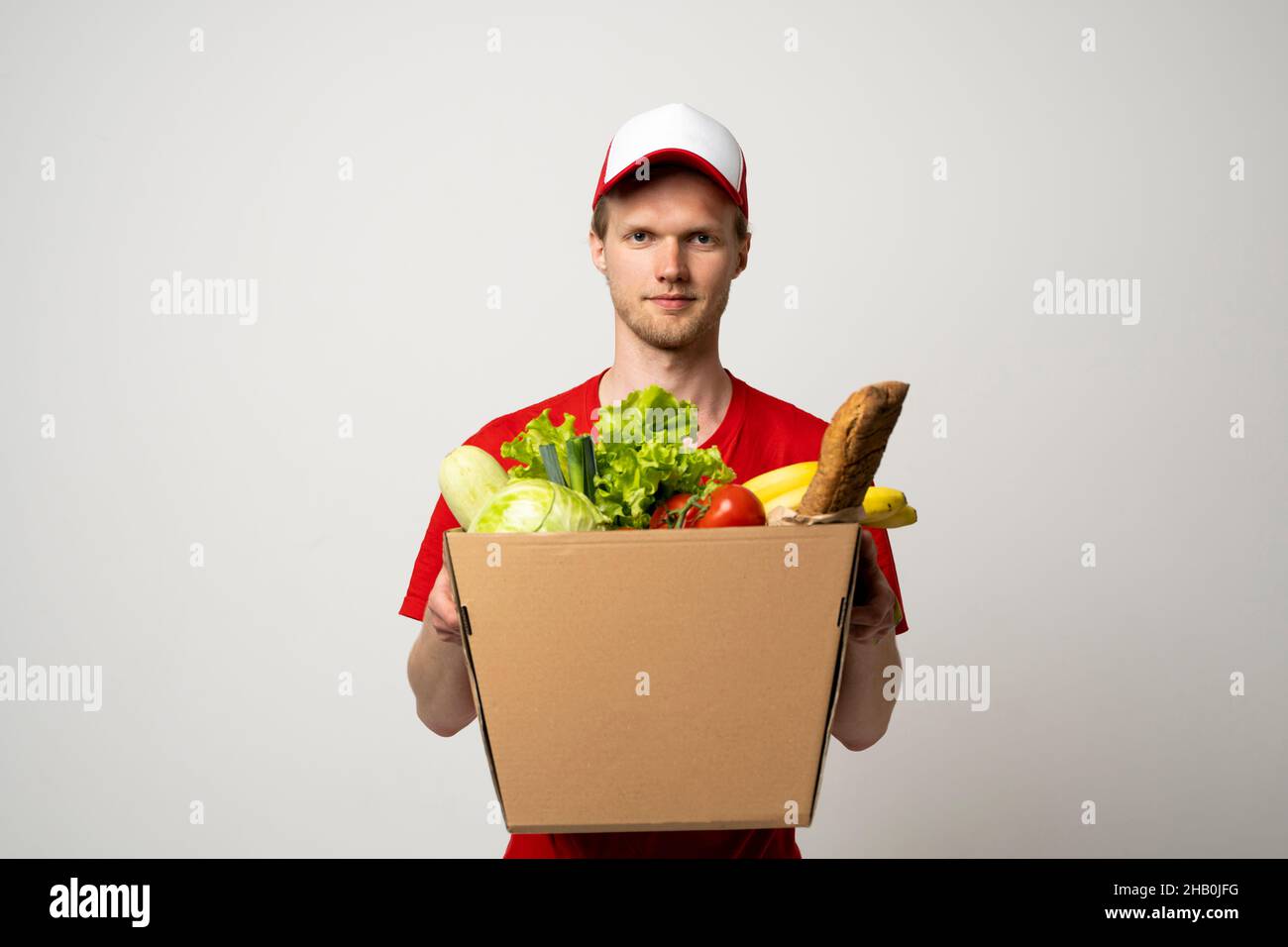 Grocery store delivery man wearing an red t-shirt delivering food to a ...