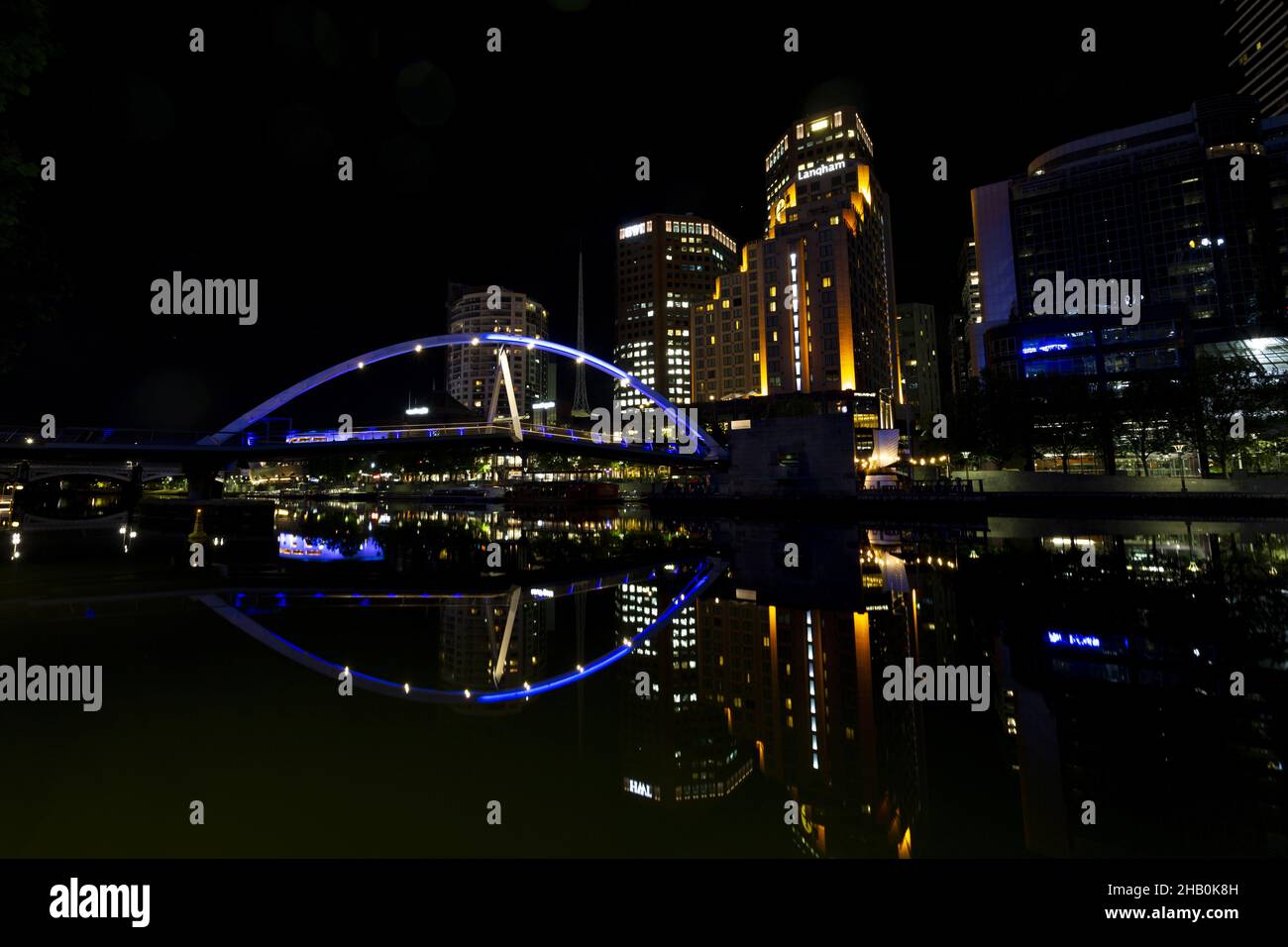 Scenic cityscape with high buildings and a beautiful bridge at night ...