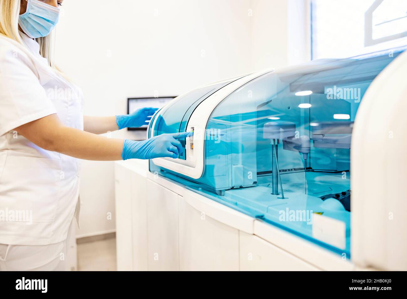 Sampling machine in a modern lab. A nurse standing next to a machine ...
