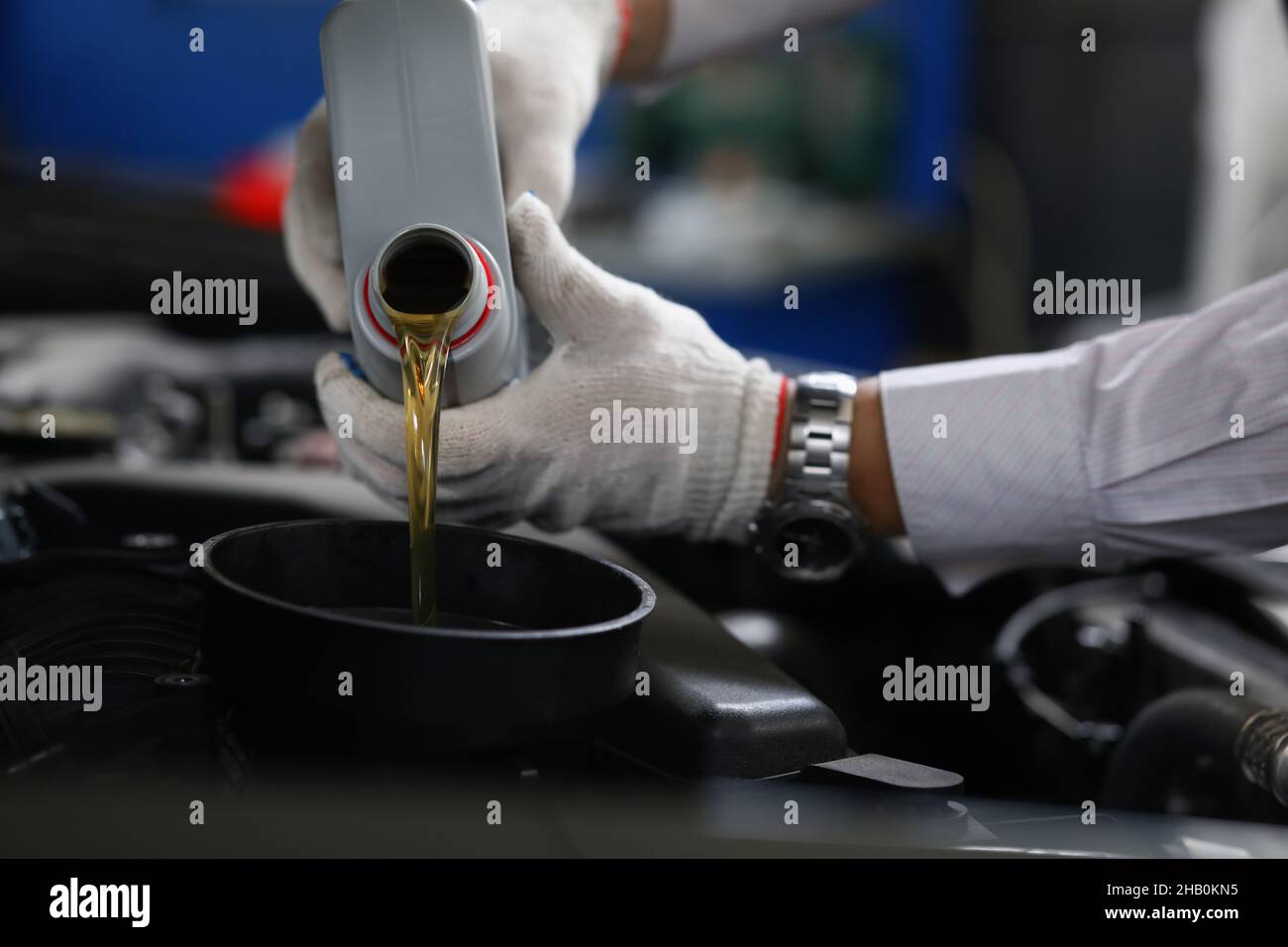 Worker refueling and pouring new oil into engine motor car Stock Photo ...