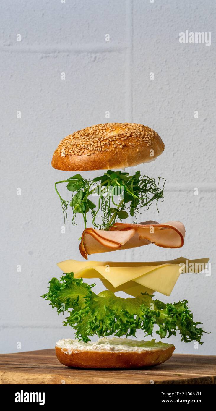 Vertical closeup of the floating ingredients of the burger Stock Photo ...