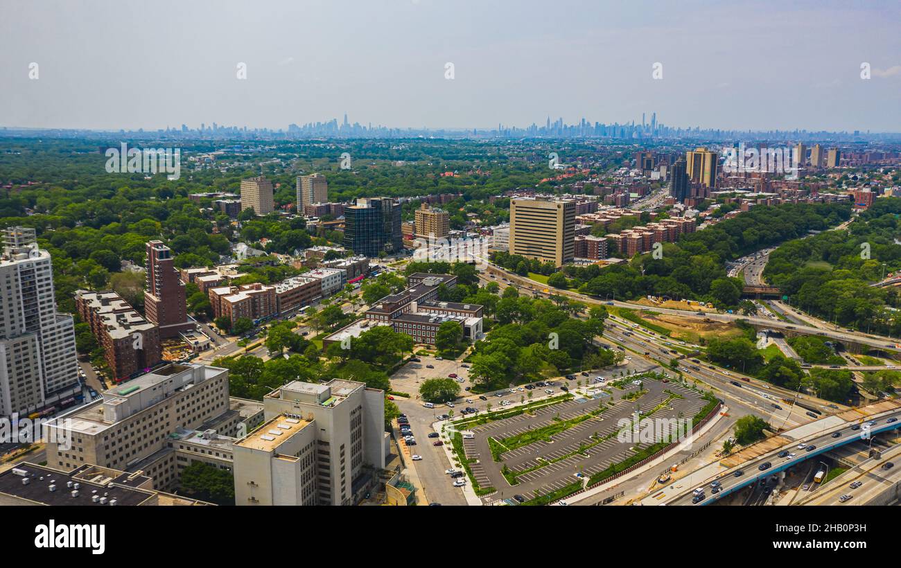 Aerial view of a city with dense buildings and trees under a blue clear ...