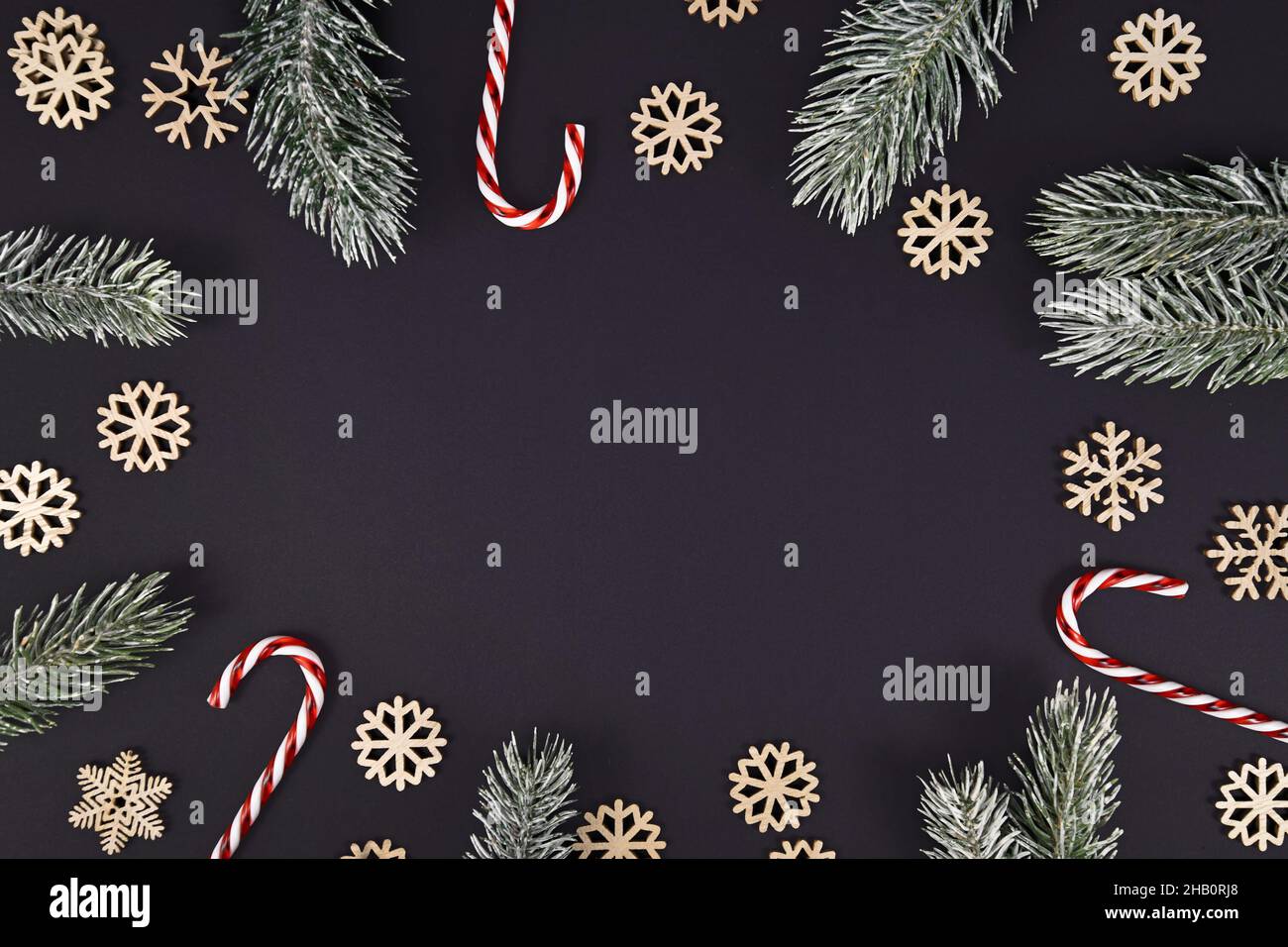 Winter fir branches, candy canes and snowflakes forming border around ...