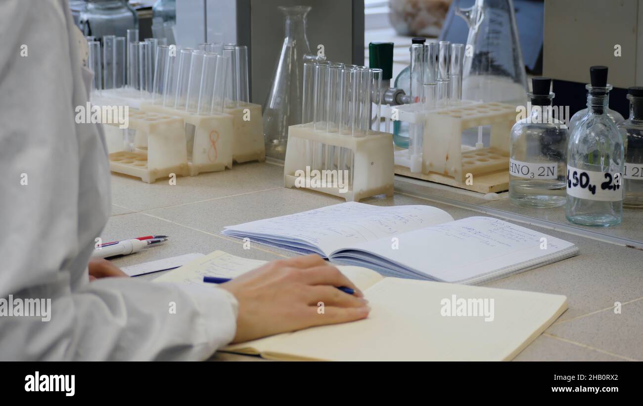 Young scientist doctor taking notes. Female scientist takes notes in ...