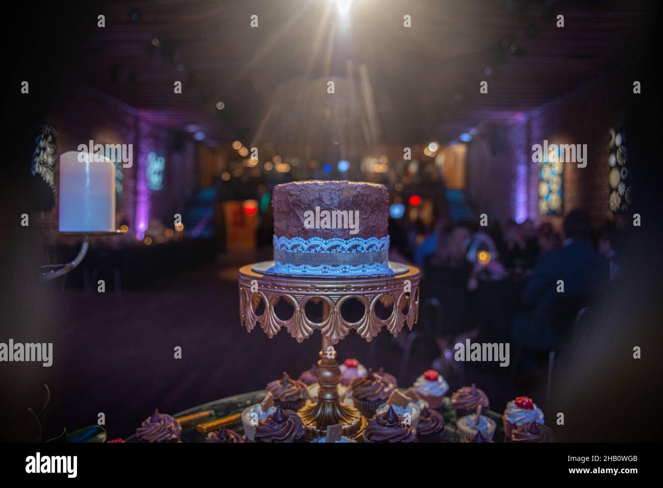 Chocolate one tier wedding cake with lace decoration and bows on gold ...