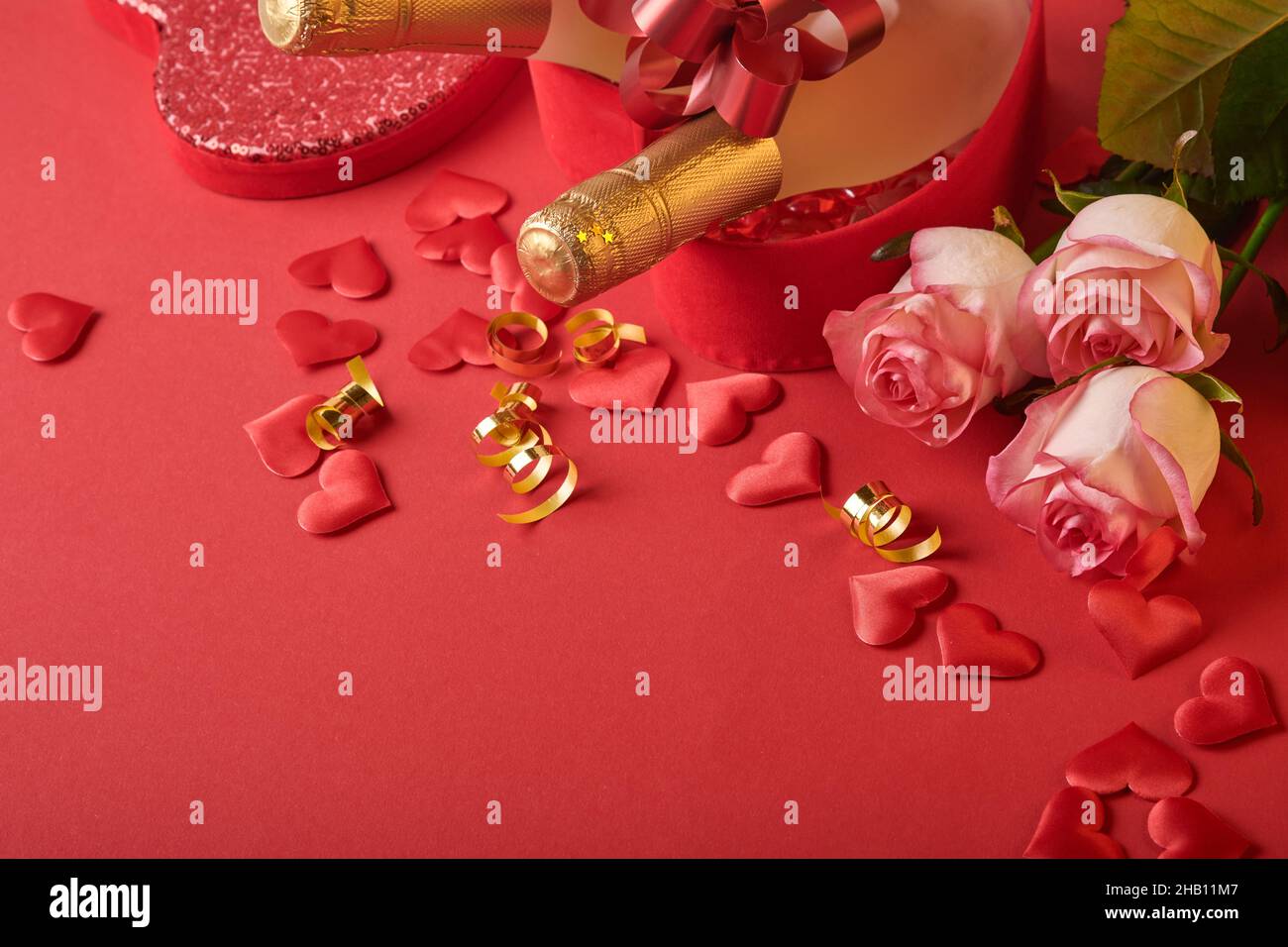 Pink roses flowers, champagne, gift, golden ribbons and confetti red ...