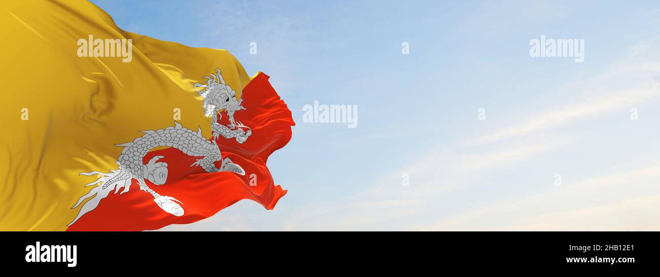 official flag of Bhutan at cloudy sky background on sunset, panoramic ...